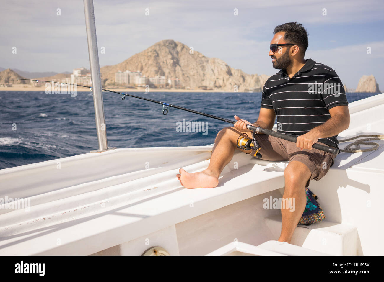 Young East Asian man fishing on open water from the boat. Beautiful ...
