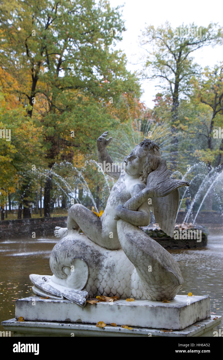 A gray and white marble statue of Cupid riding on a dolphin. The statue ...