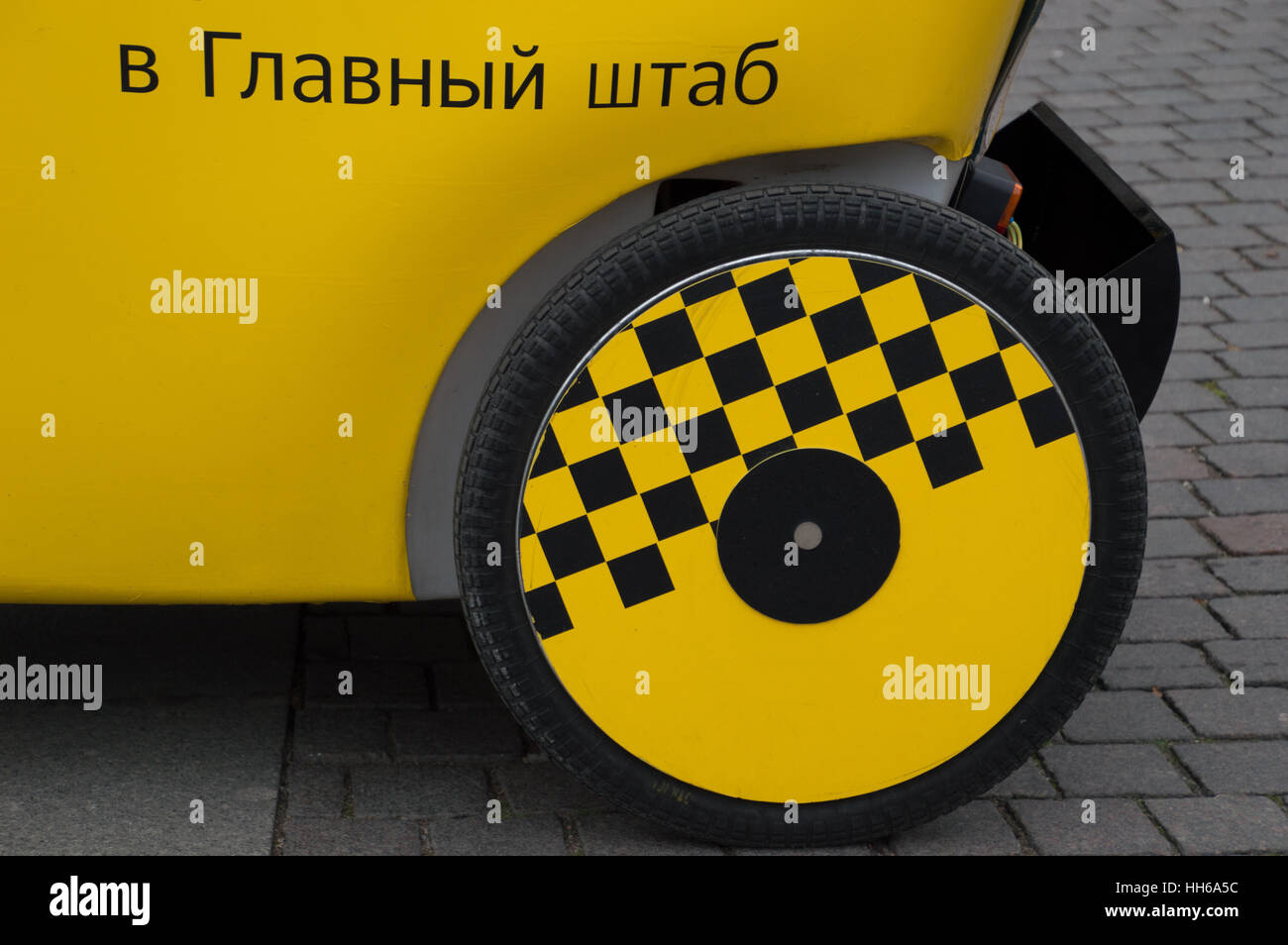 Close up of yellow and black checkerboard wheel on a taxi with Russian ...