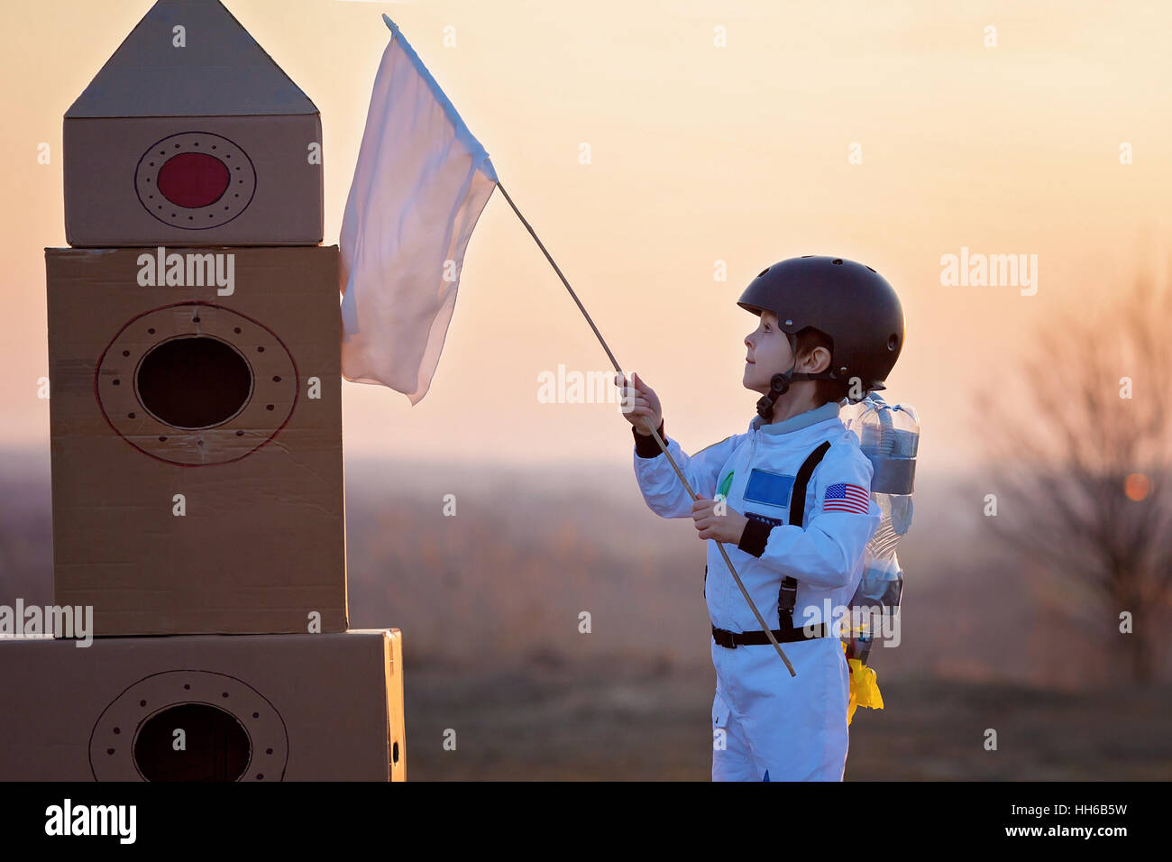 Adorable little boy, dressed as astronaut, playing in the park with ...