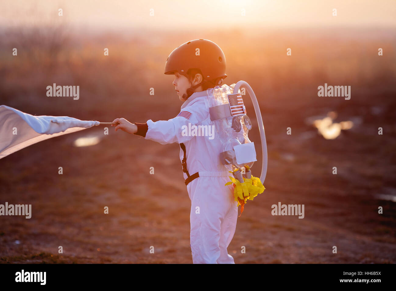 Adorable little boy, dressed as astronaut, playing in the park with ...