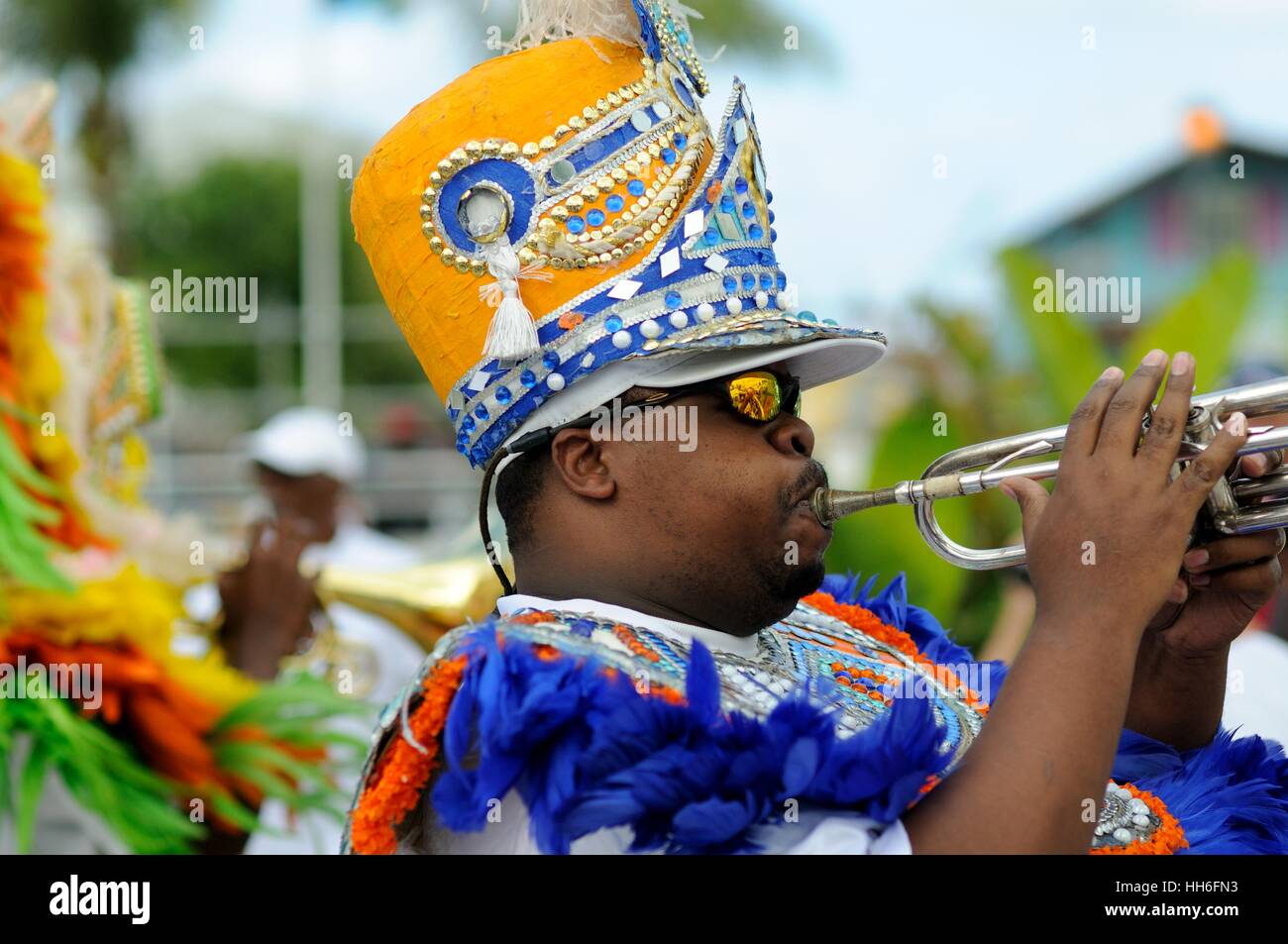 trumpet player in carnival dress in a Junkanoo band playing in a street ...