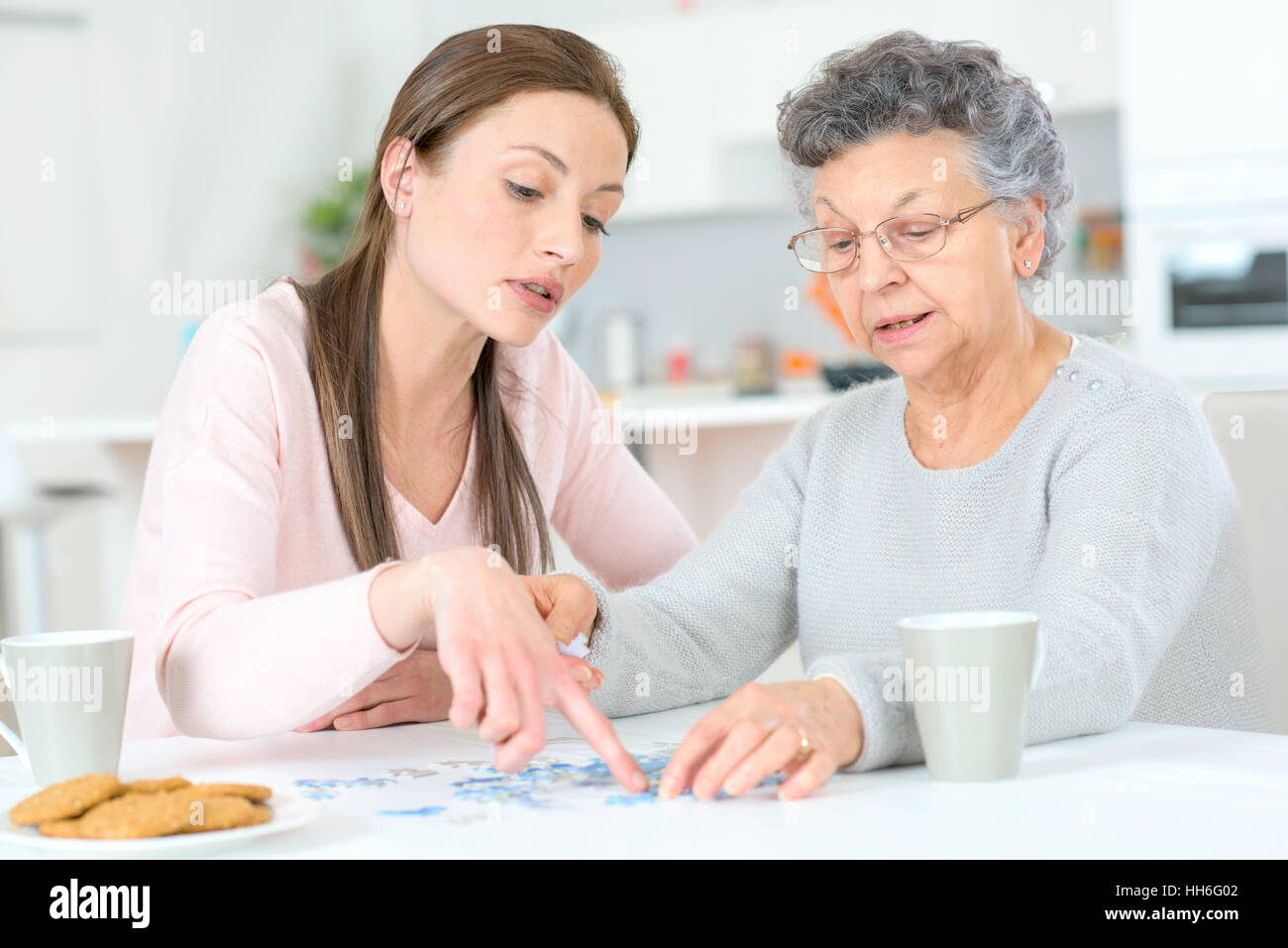 Old lady doing a jigsaw puzzle Stock Photo - Alamy