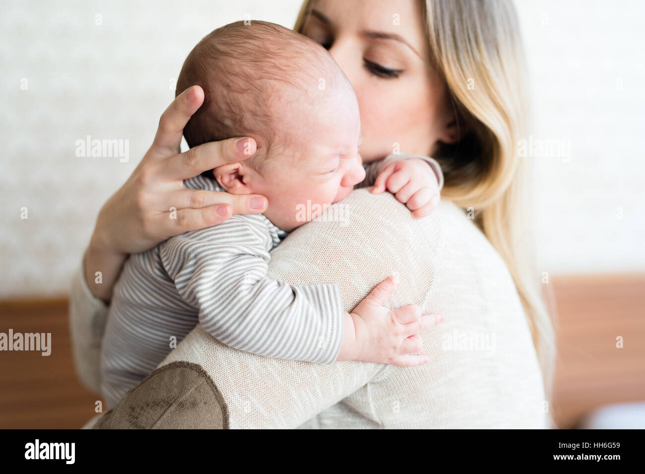 Beautiful young mother holding baby son in her arms Stock Photo - Alamy