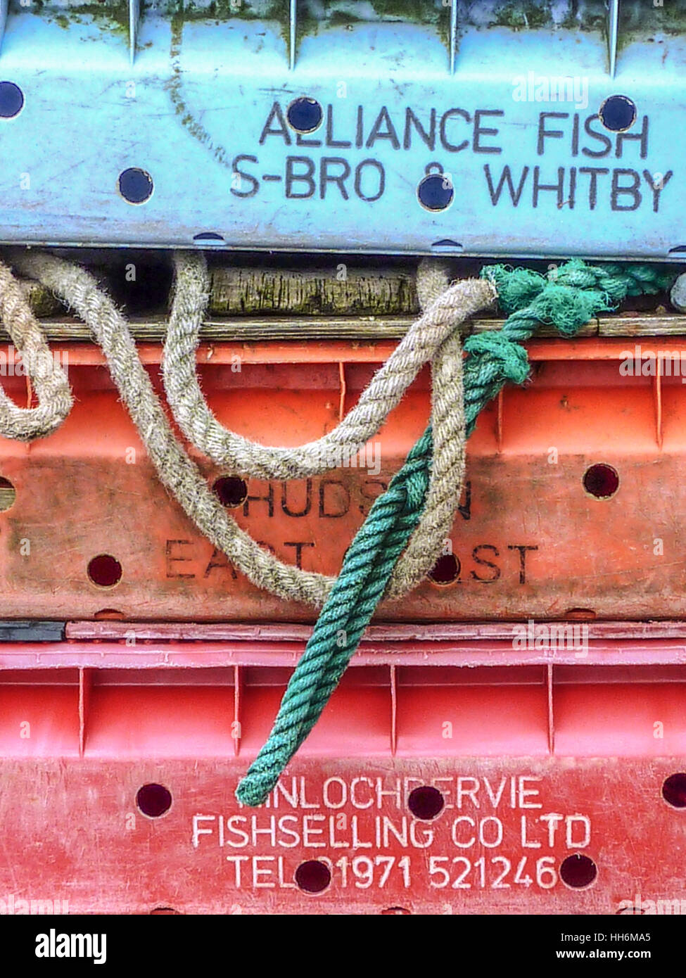A stack of fishing boxes on a jetty in Scotland Stock Photo - Alamy