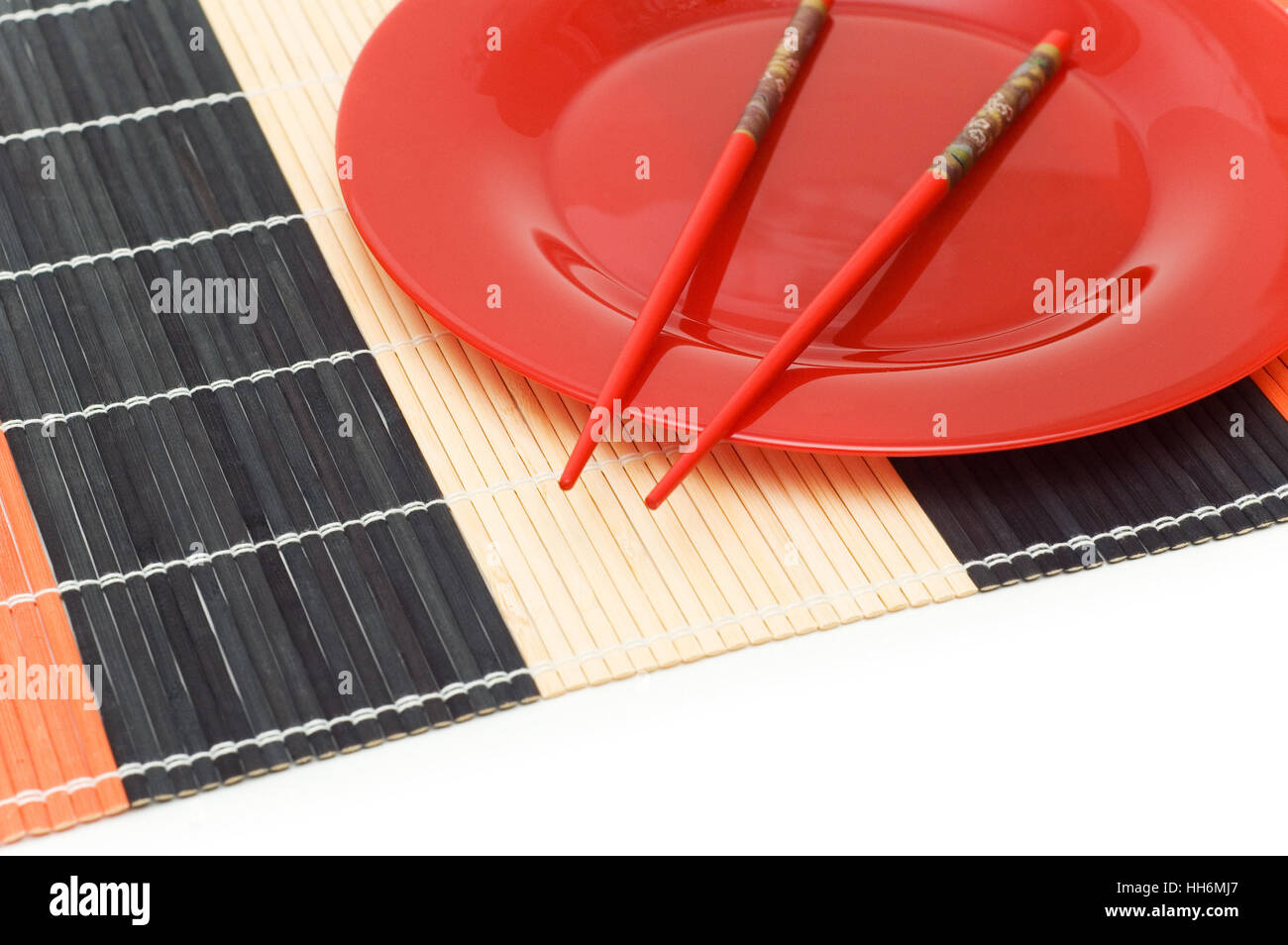 Red plate with chopsticks isolated on white Stock Photo - Alamy