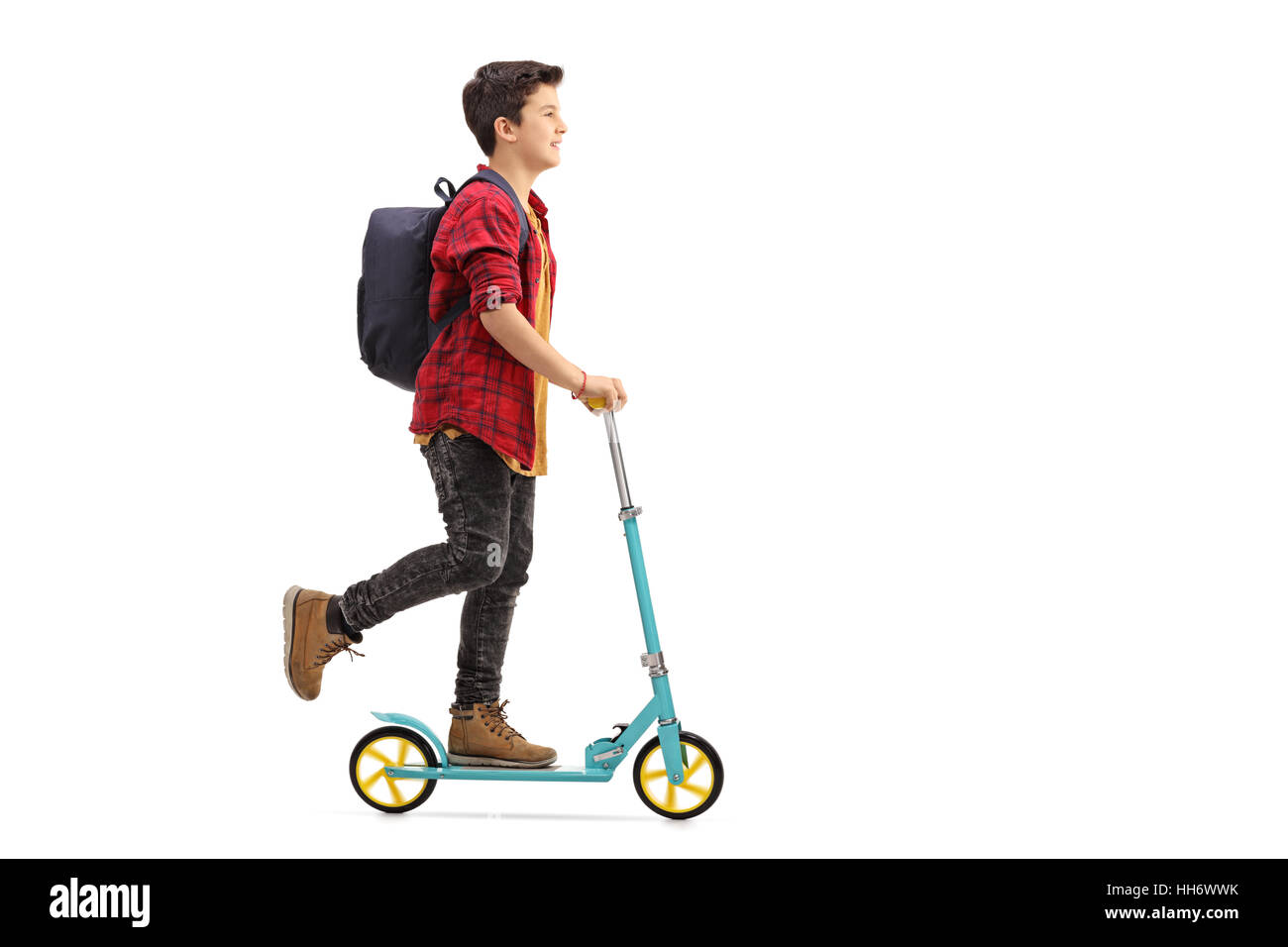 Full length profile of a happy kid riding a scooter isolated on white ...