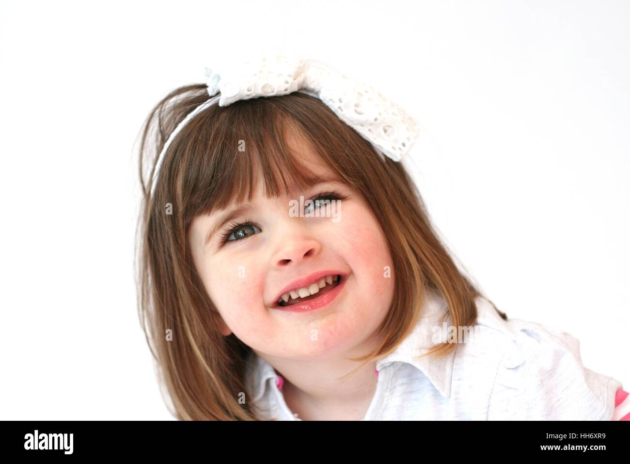 Little girl,child looking up smiling wearing a white bow, fridge white ...