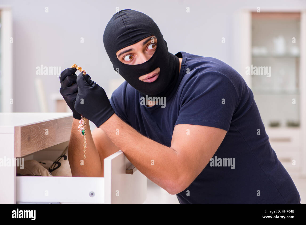 Robber wearing balaclava stealing valuable things Stock Photo - Alamy