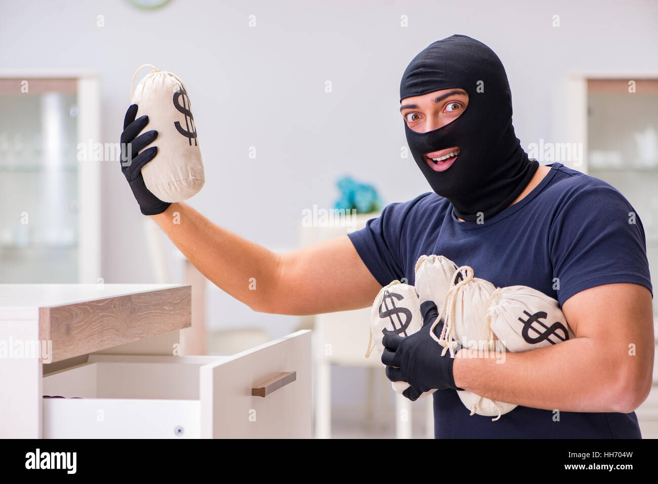 Robber wearing balaclava stealing valuable things Stock Photo - Alamy