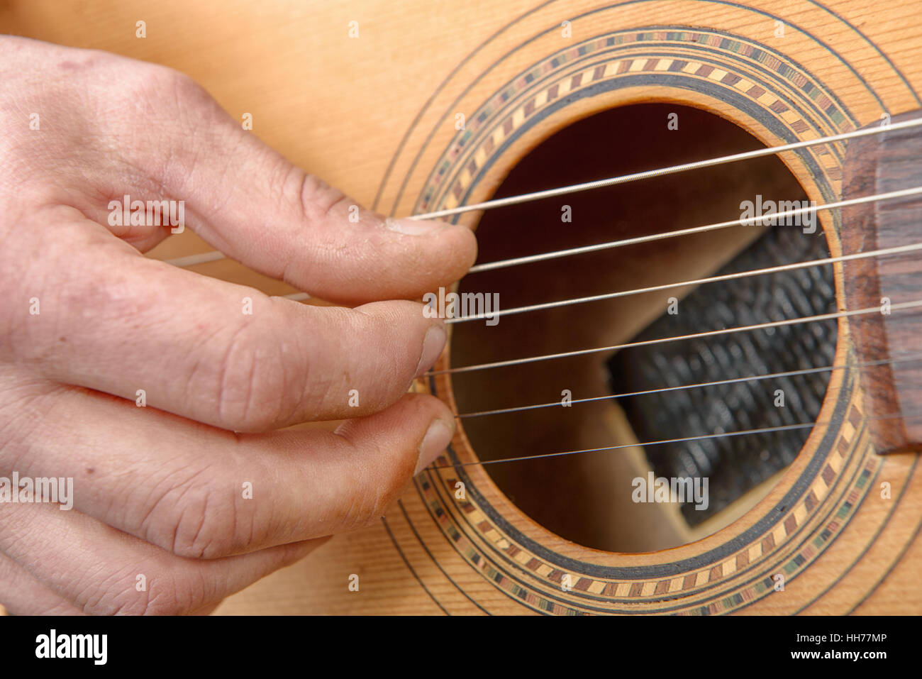 Close-up view of man's hand playing the acoustic guitar Stock Photo - Alamy