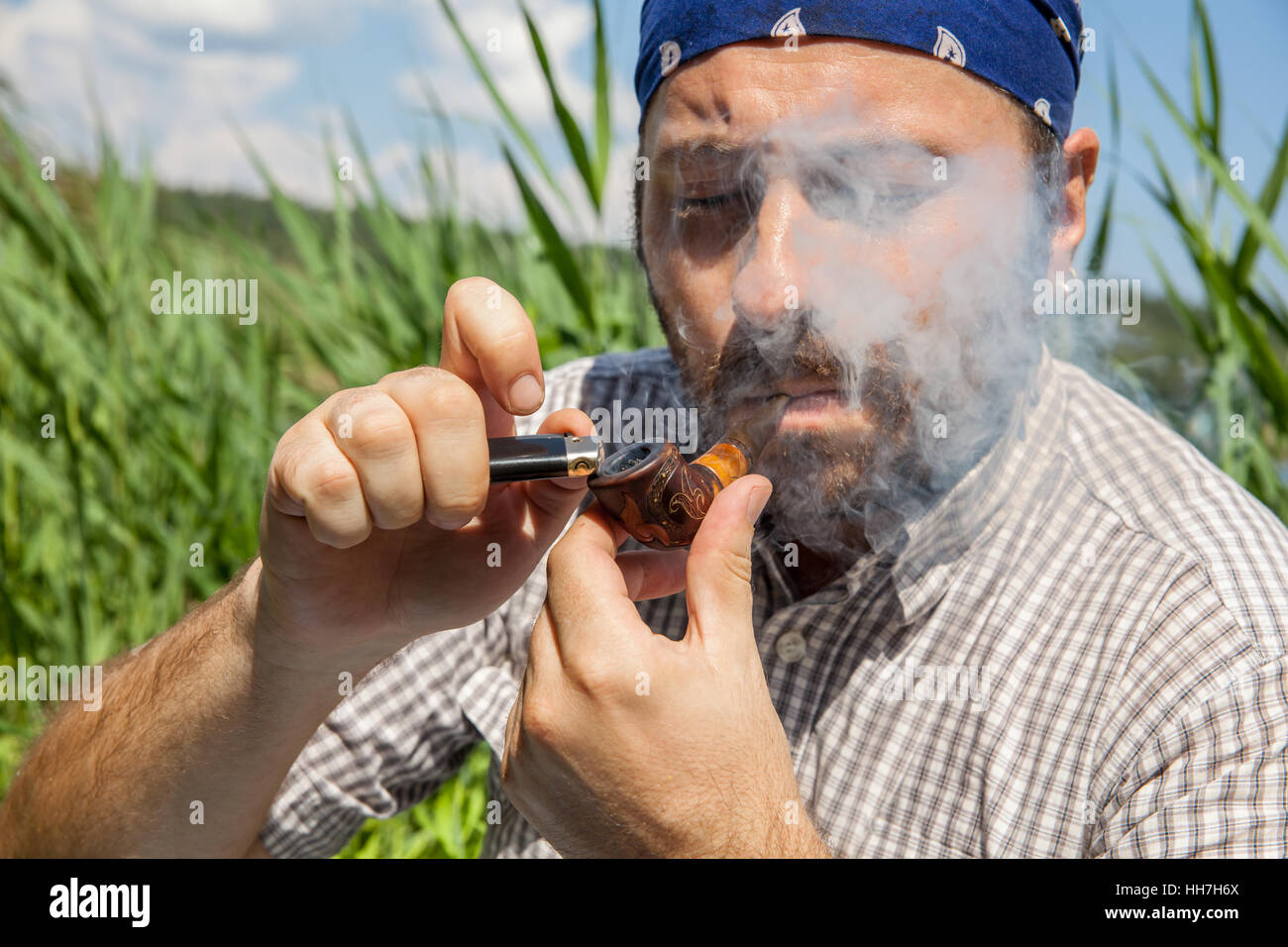 Bearded man lighting his pipe outside on a summer day Stock Photo - Alamy