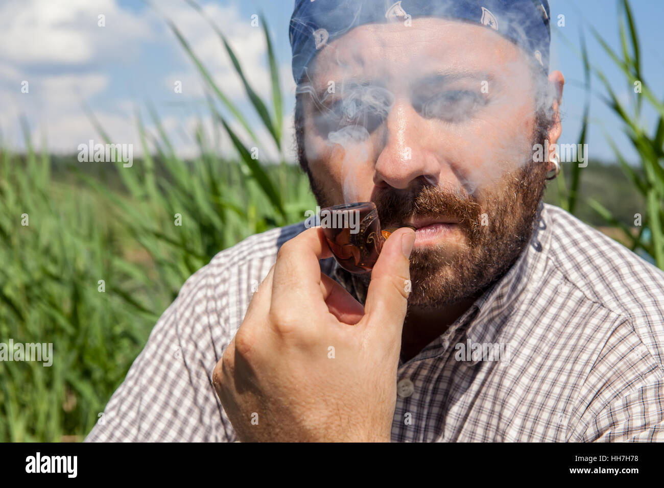 Bearded man smoking his pipe outside on a summer day Stock Photo - Alamy