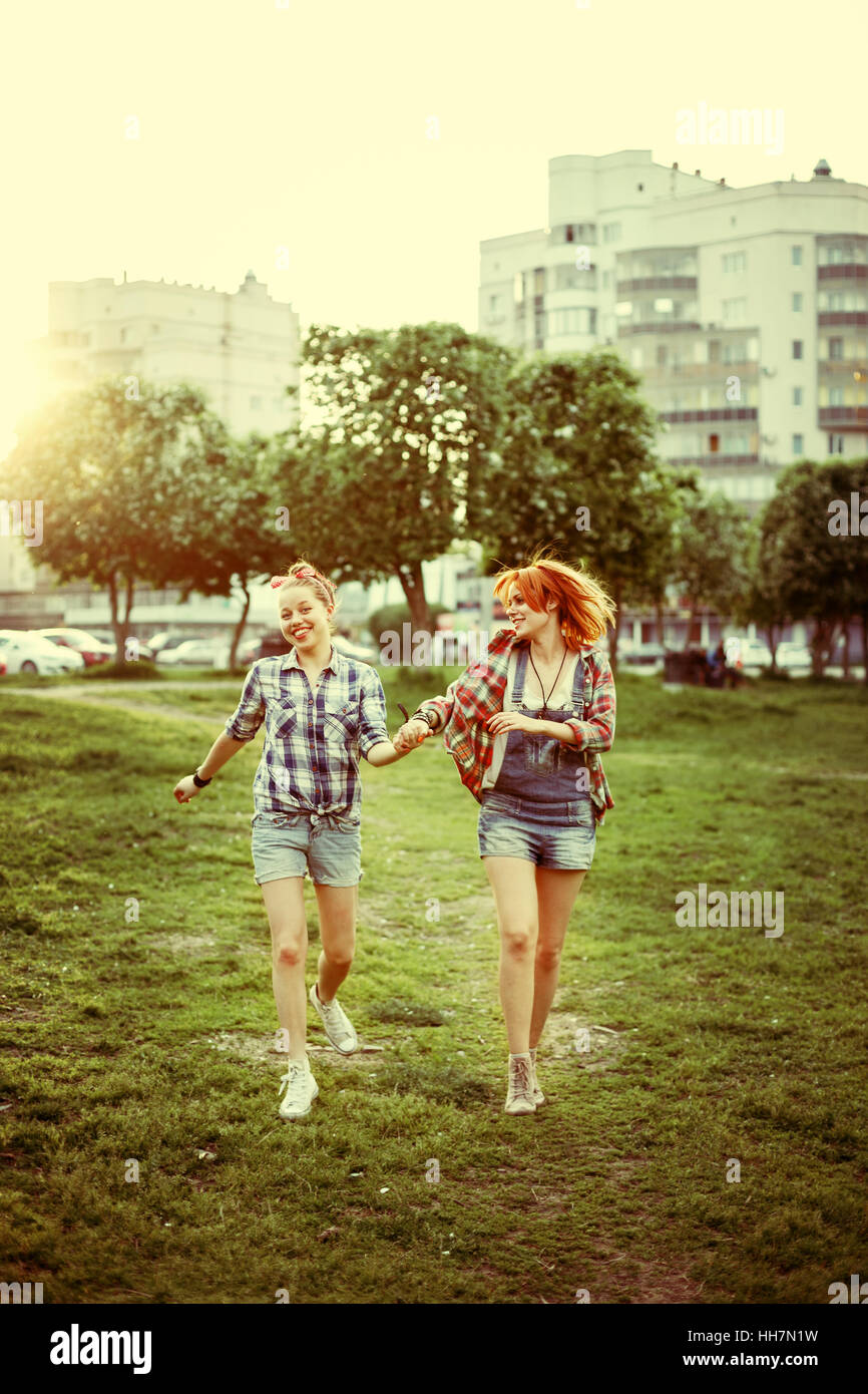 Young happy beautiful best friends girls in having fun in city park ...