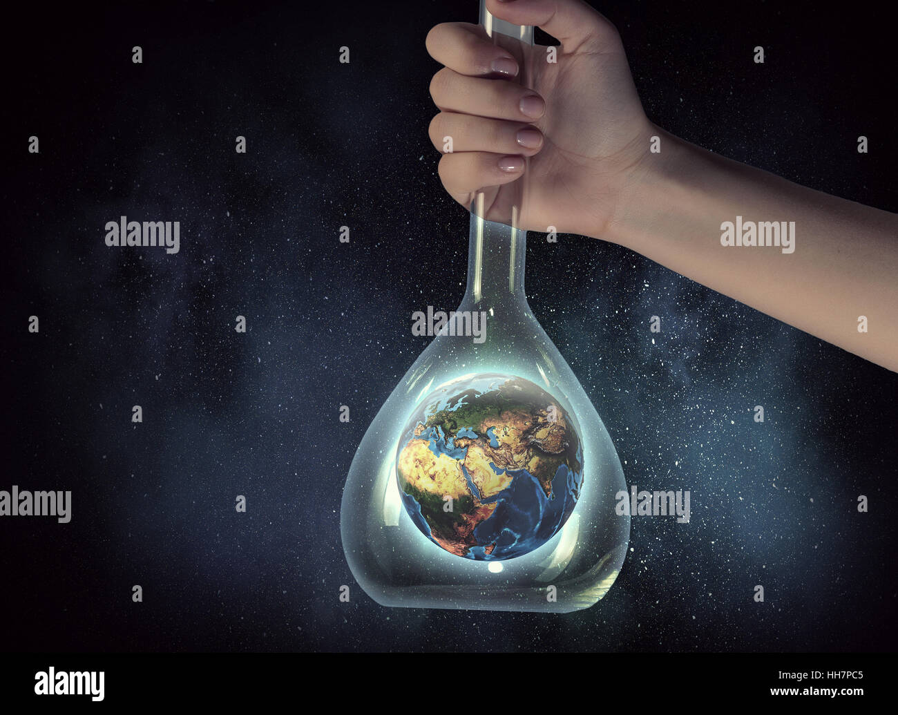 Close up of human hand holding test tube with Earth planet. Elements of ...
