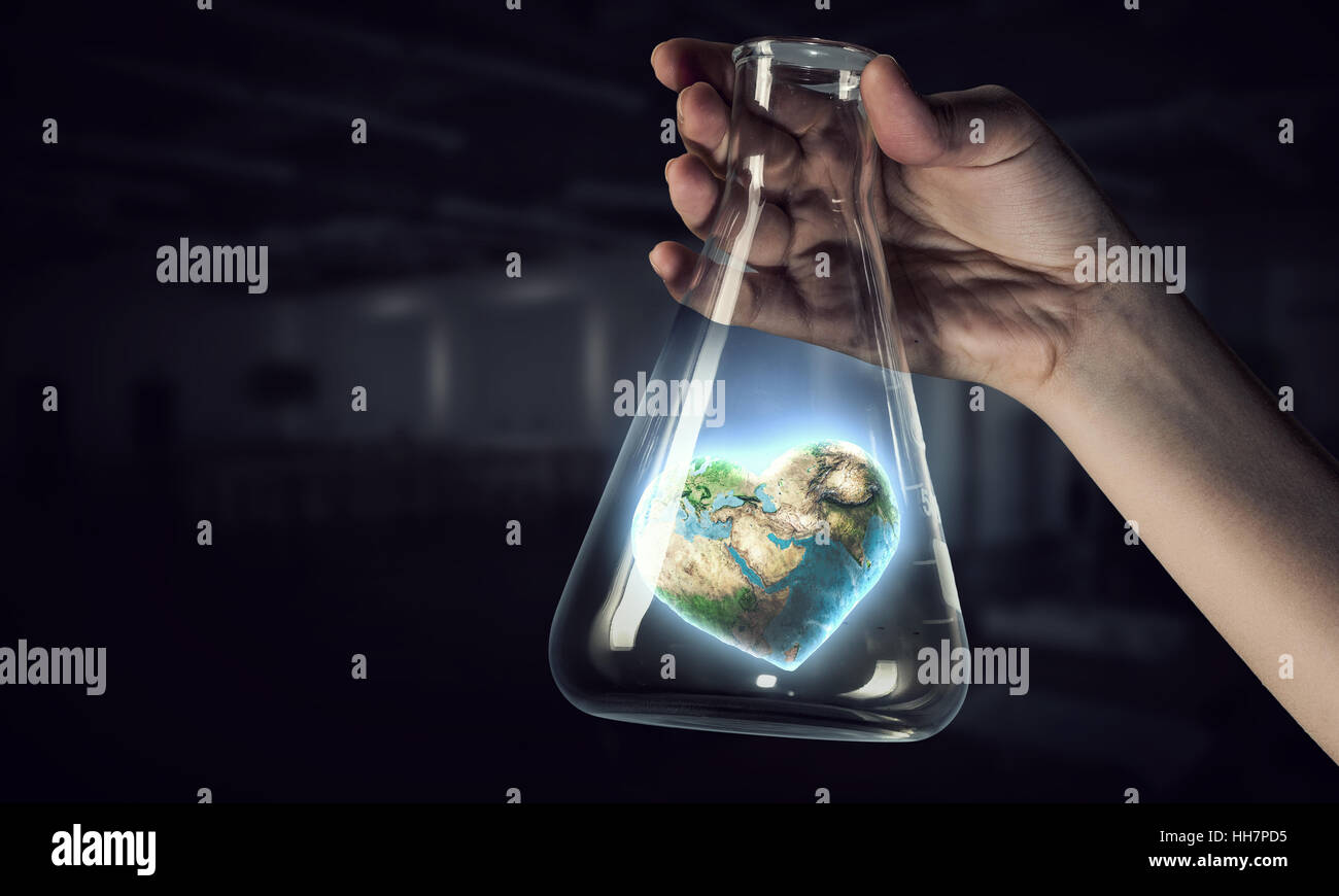 Close up of human hand holding test tube with Earth planet. Elements of ...