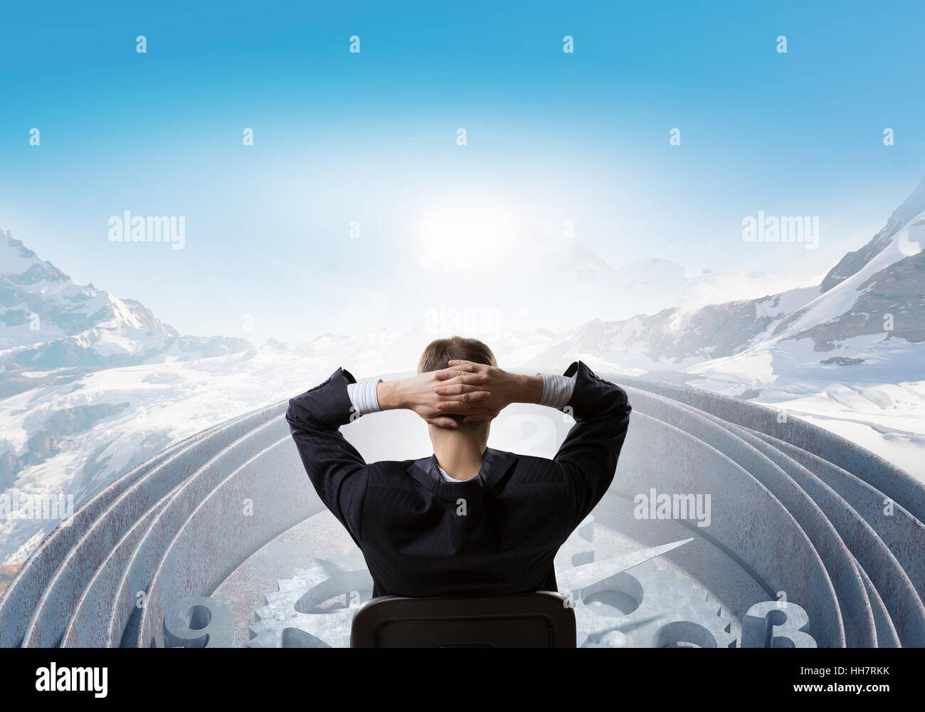 Back view of relaxed businessman sitting on chair with hands on nape ...
