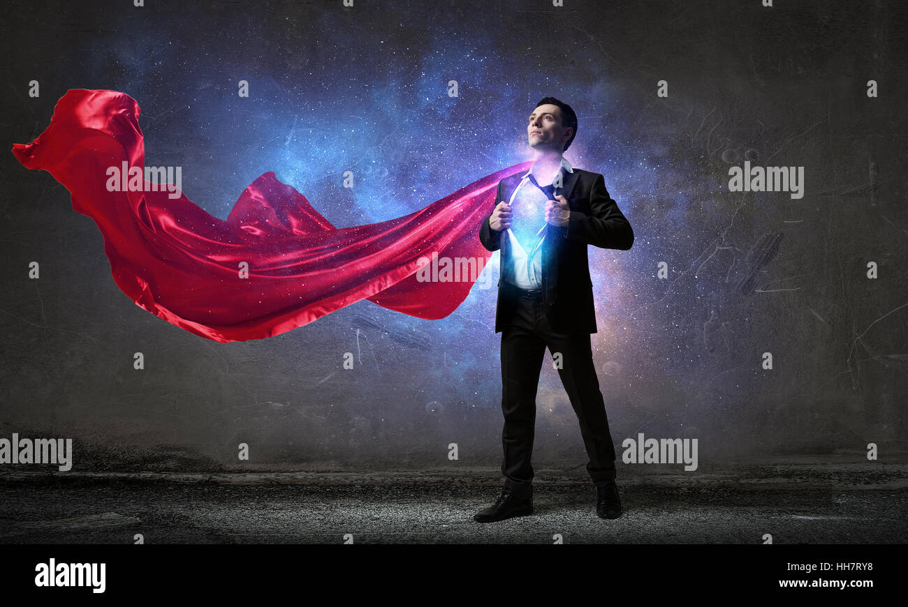 Young businessman dressed as superhero against concrete background ...
