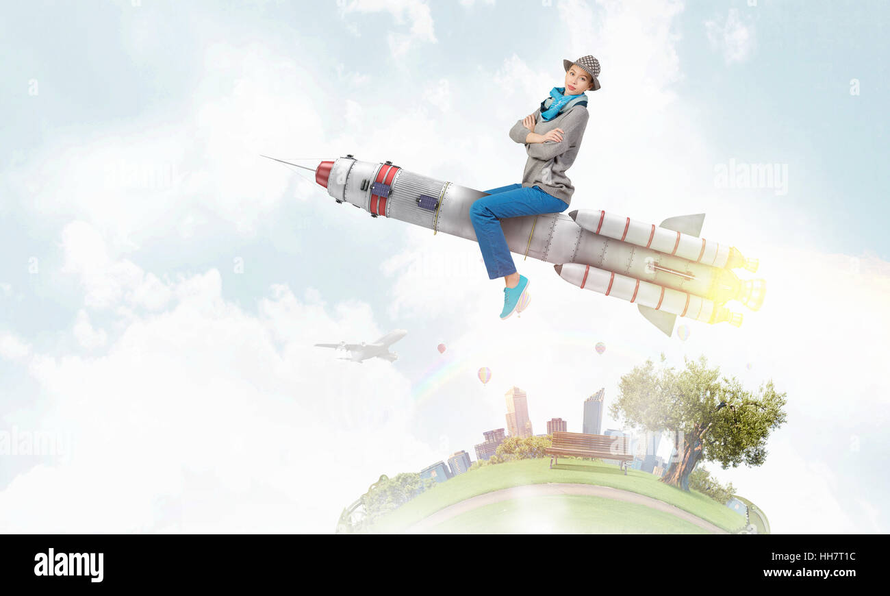 Young cheerful woman traveller riding rocket high in sky Stock Photo ...