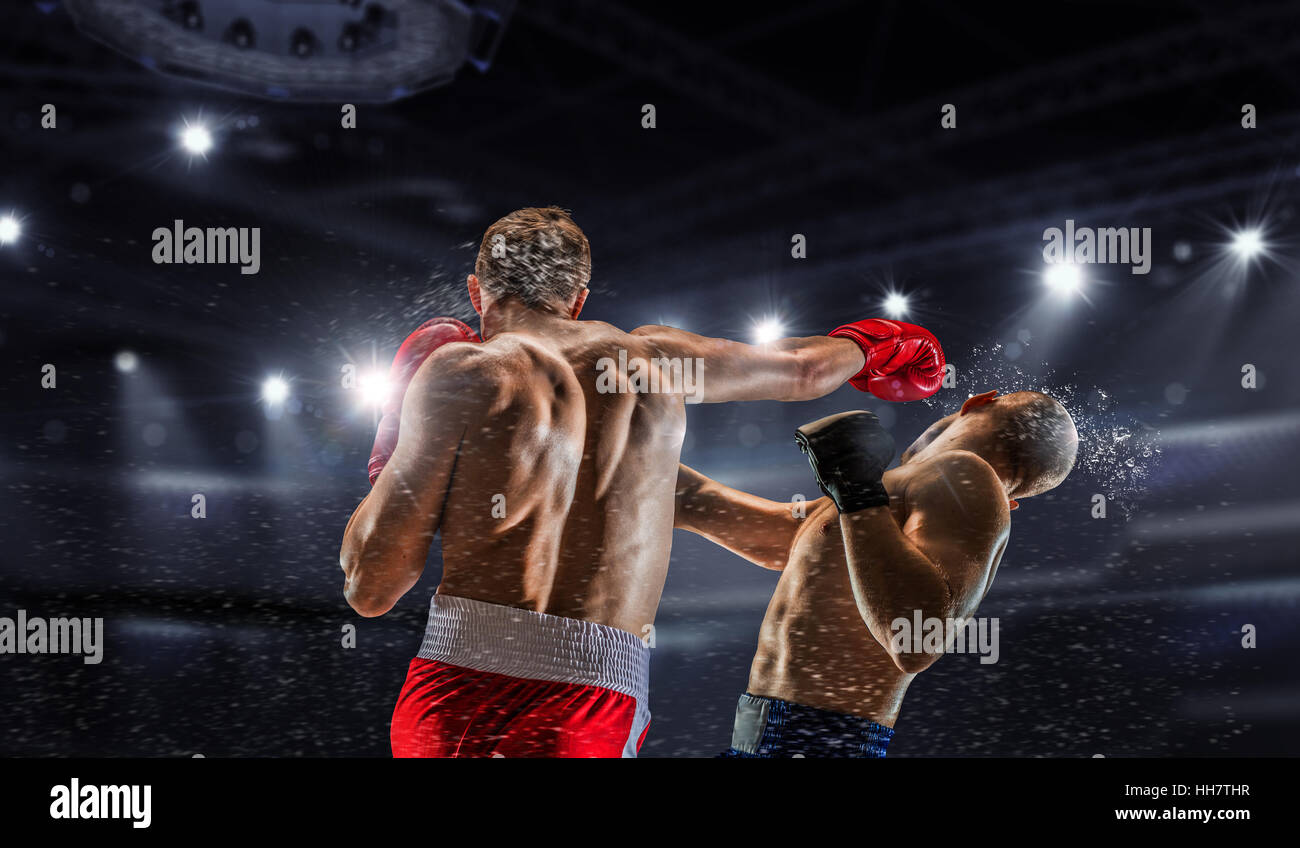 Two professional boxers fighting at sport arena. Mixed media Stock ...