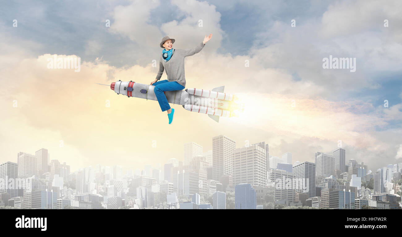 Young cheerful woman traveller riding rocket high in sky Stock Photo ...