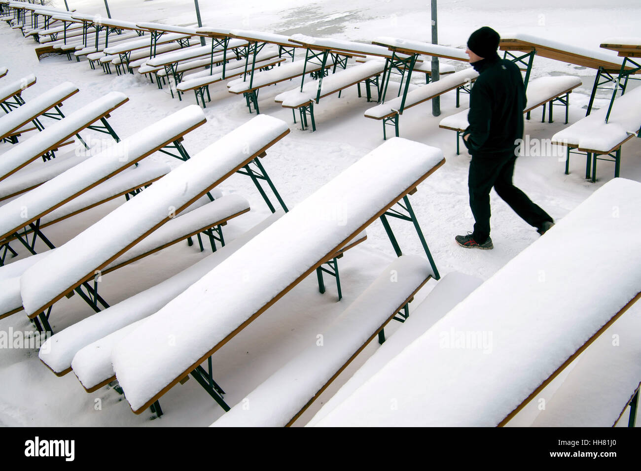 A man walks through a snow-covered beer garden in the English Garden in ...