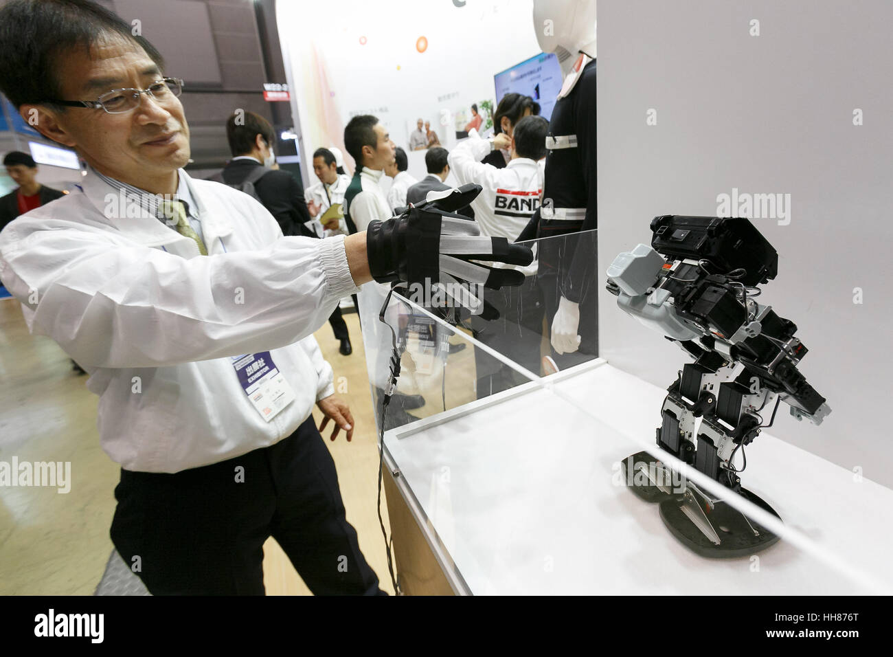 An exhibitor controls a robot with a wearable sensor system at the ...