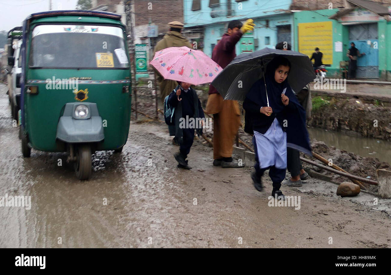 School students are passing through path during rain towards school in ...