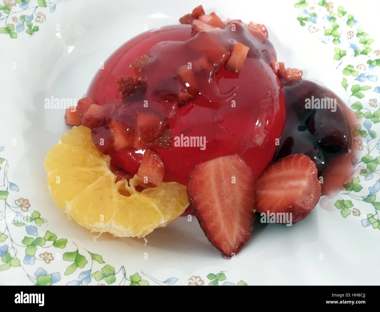 Strawberry jelly dessert flavored with half piece of strawberry, berry ...