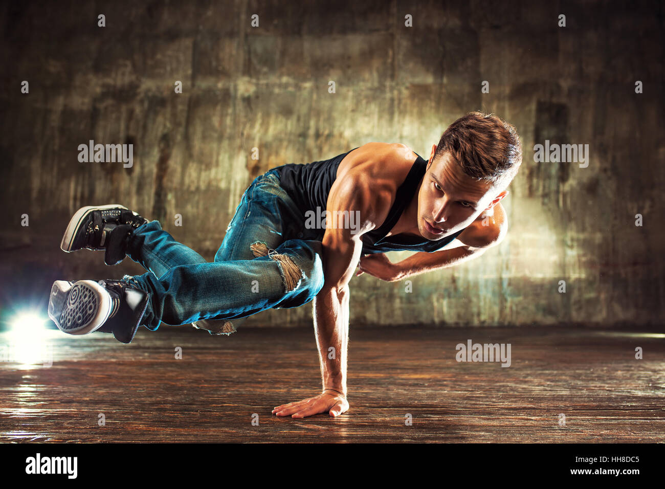 Young man break dancing on old wall background Stock Photo - Alamy