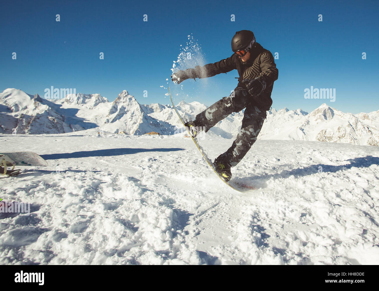 Young man jumping on snowboard Stock Photo - Alamy