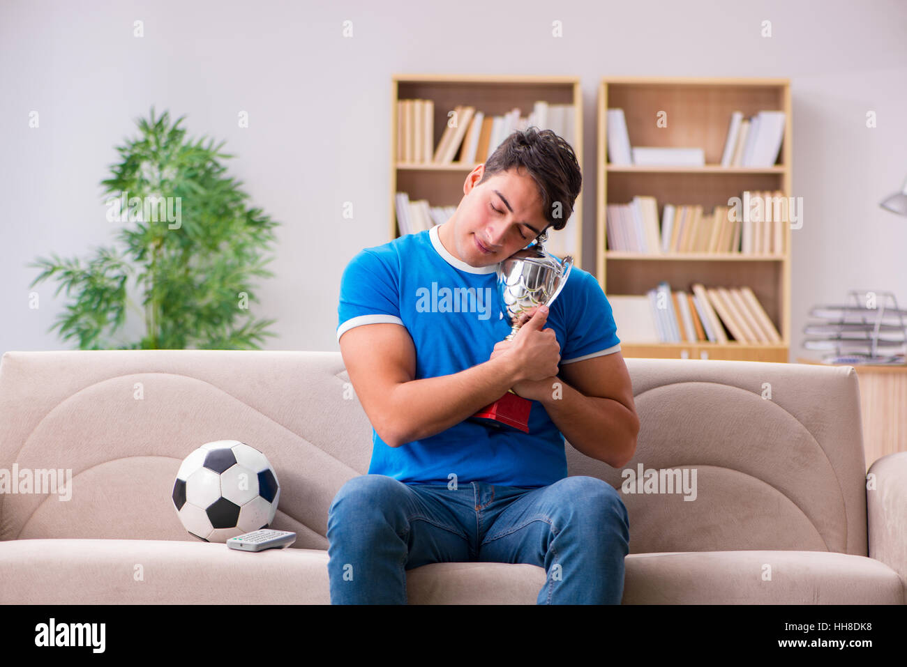 Man watching football at home sitting in couch Stock Photo - Alamy
