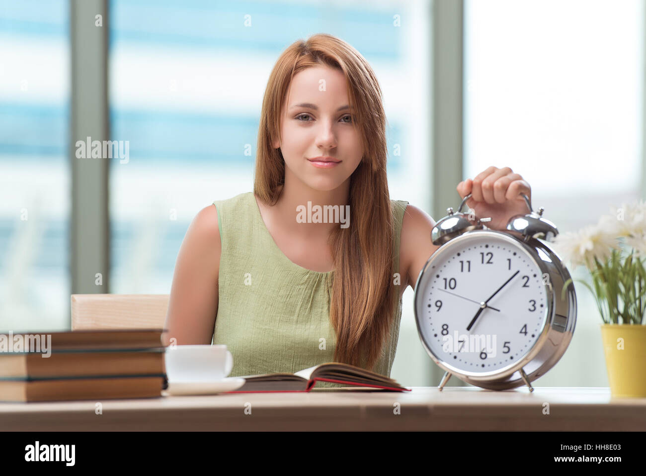 Student with gian alarm clock preparing for exams Stock Photo - Alamy
