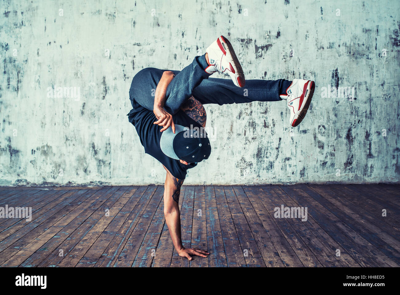 Young man break dancing on wall background Stock Photo - Alamy