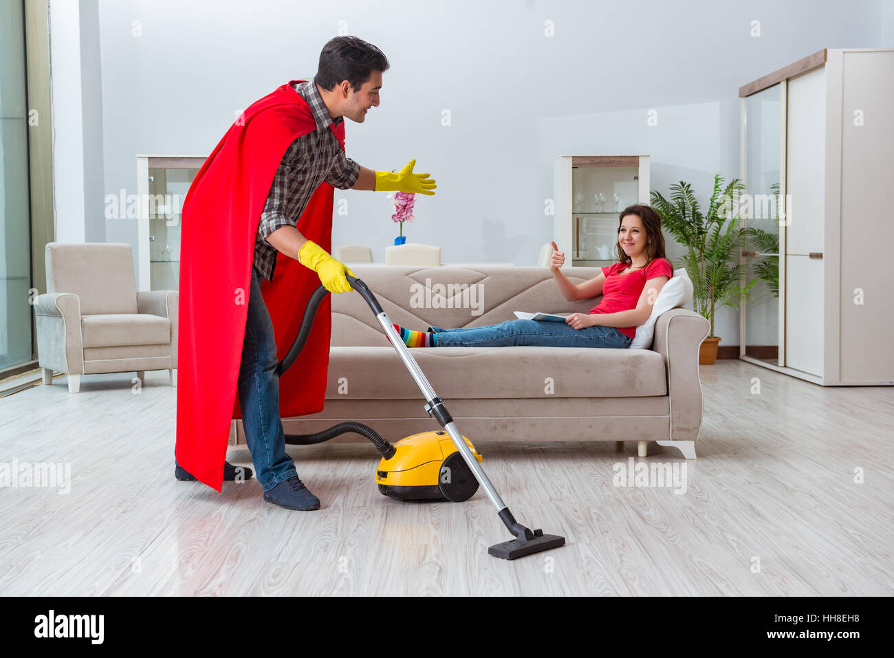 Superhero husband helping his wife at home Stock Photo - Alamy