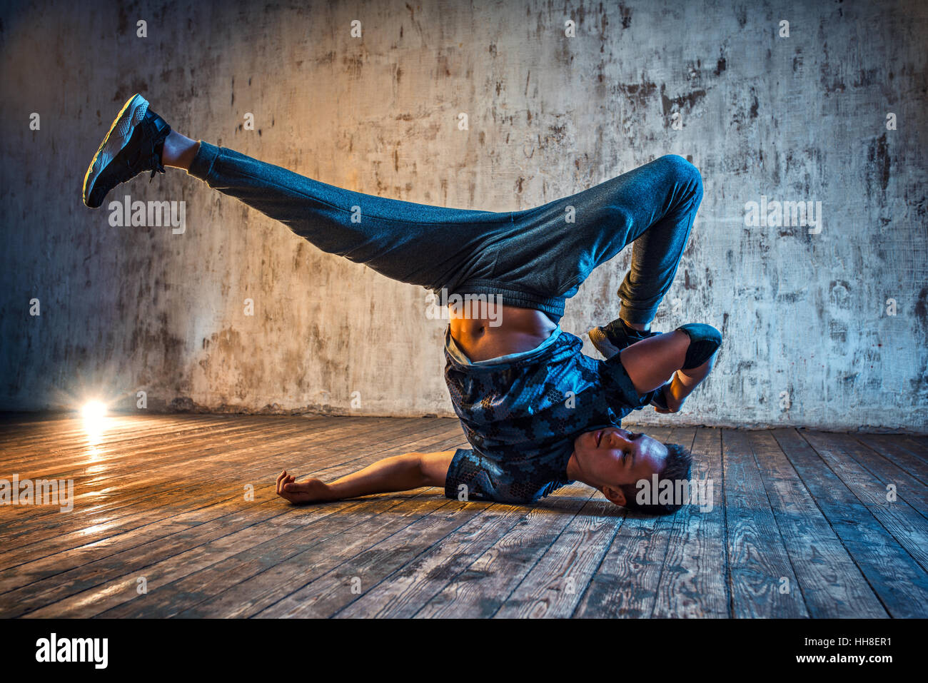 Young man break dancing on wall background Stock Photo - Alamy
