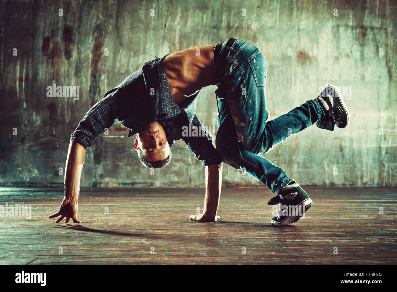 Young man break dancing on old wall background Stock Photo - Alamy