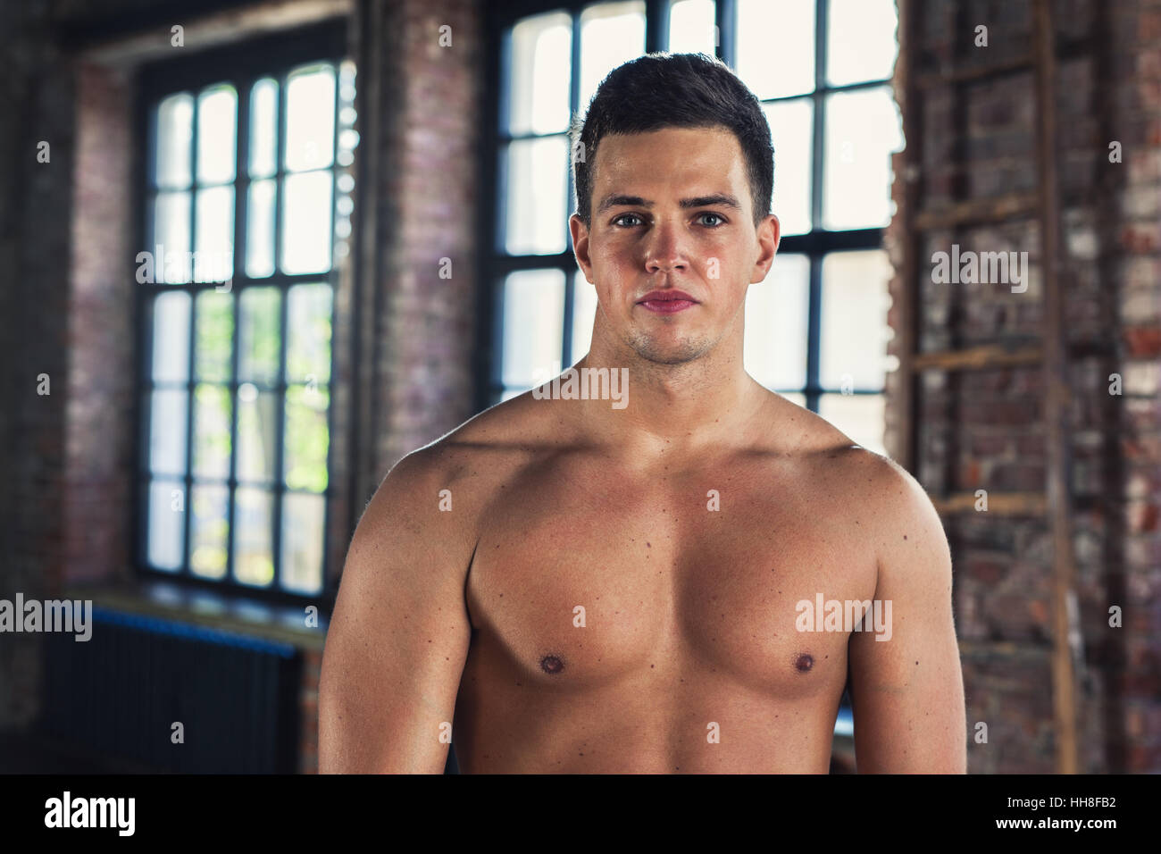 Young strong man indoors portrait Stock Photo - Alamy