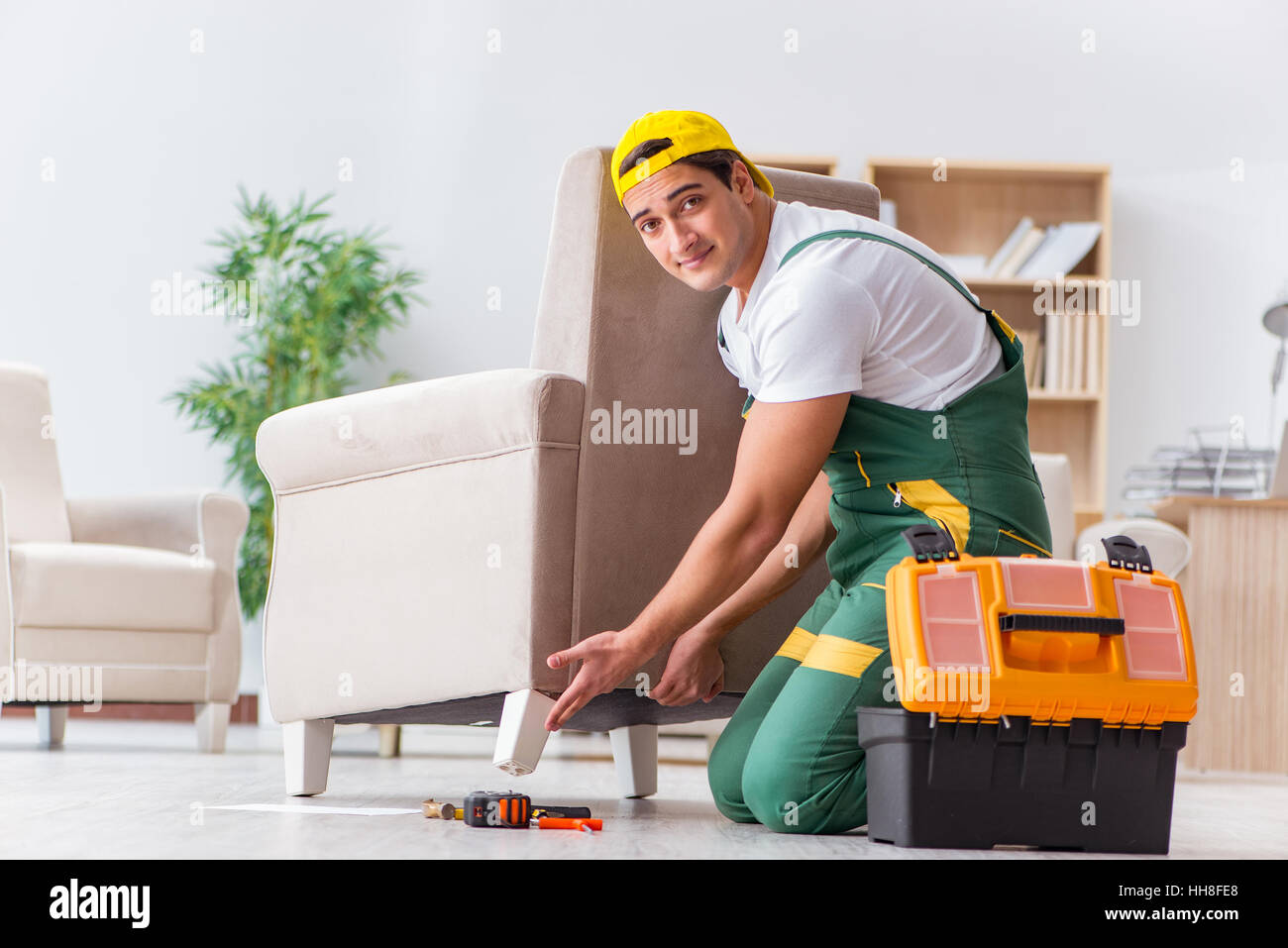 Worker repairing furniture at home Stock Photo - Alamy