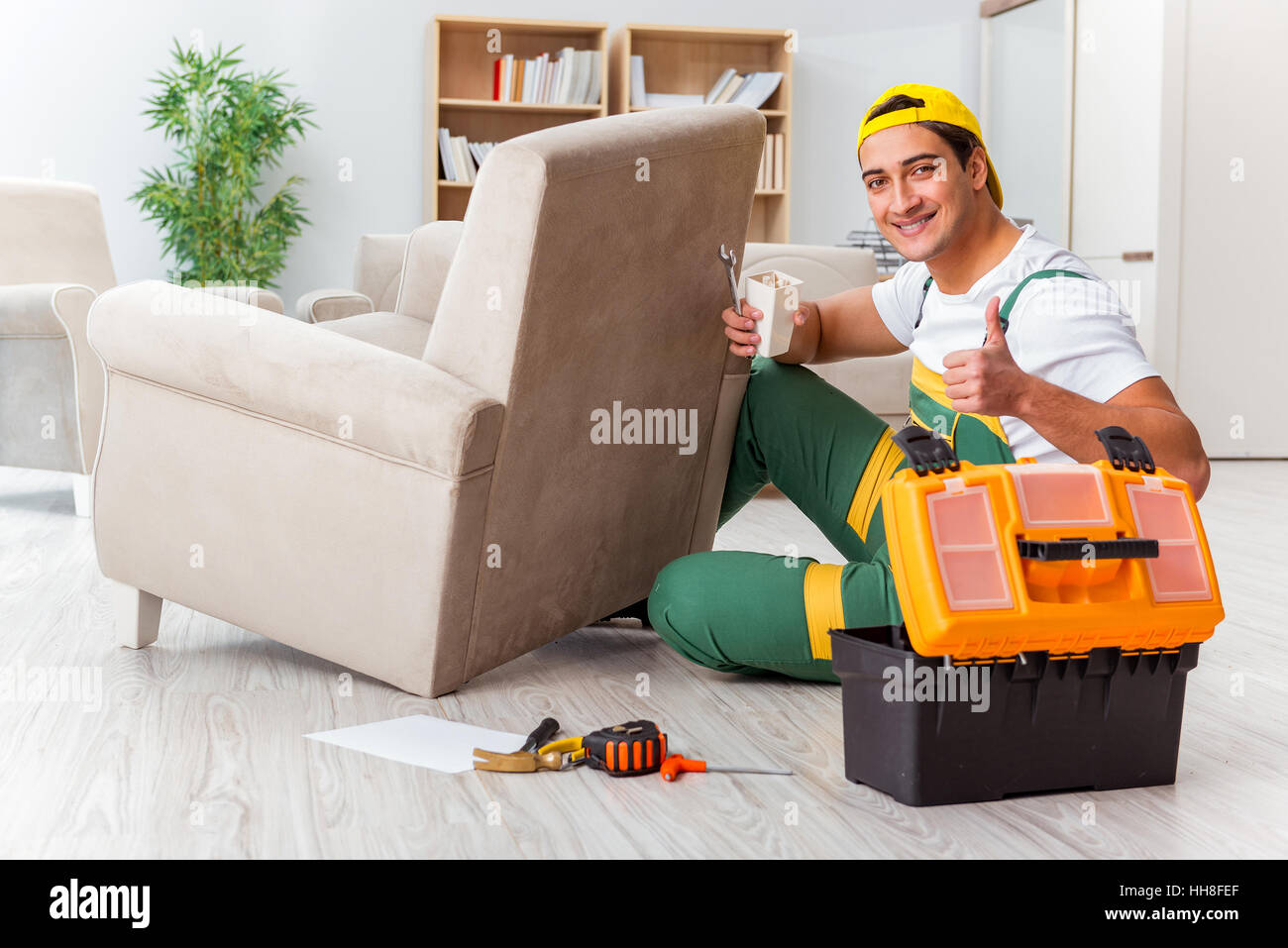 Worker repairing furniture at home Stock Photo - Alamy