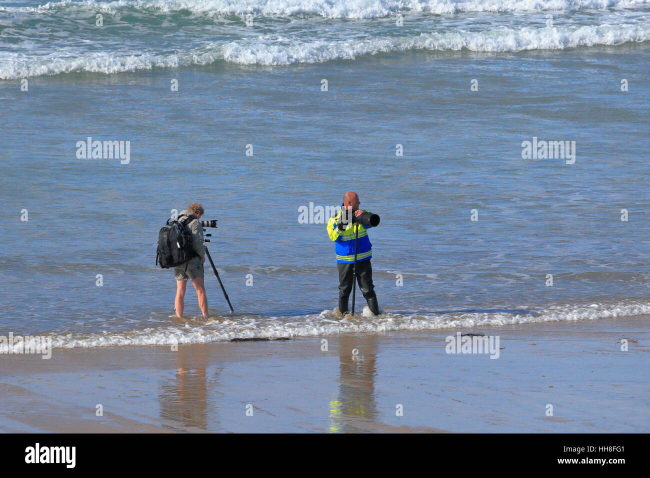Two photographers with long lenses waiting ready on beach - for what ...