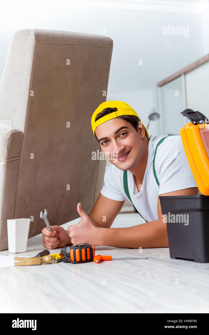 Worker repairing furniture at home Stock Photo - Alamy