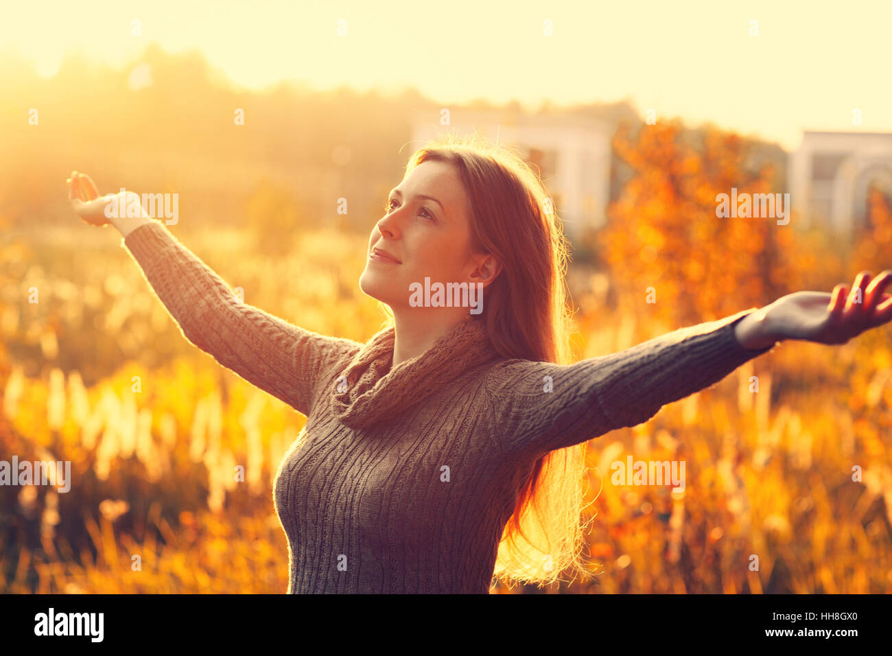 Young romantic woman enjoying good warm autumn weather and feeling free ...
