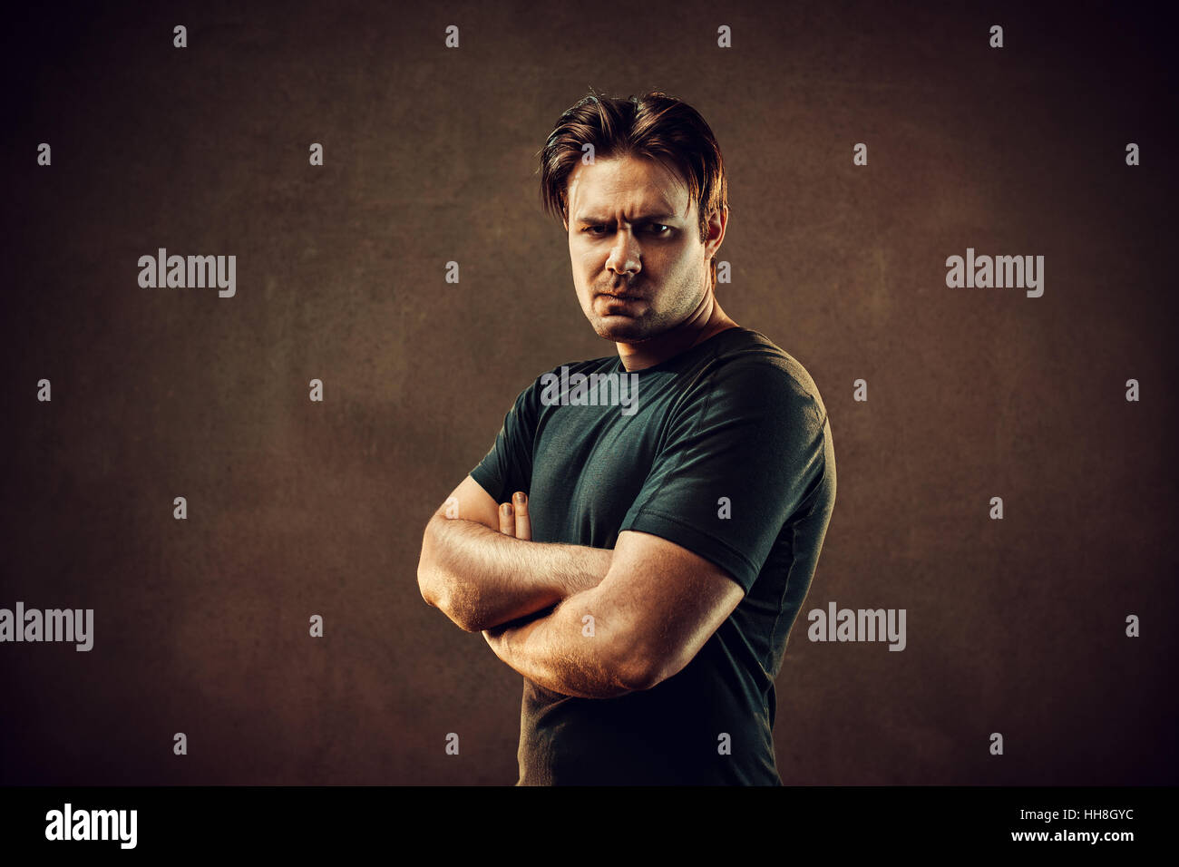 Big strong and angry man portrait. On dark stone wall background. Warm ...