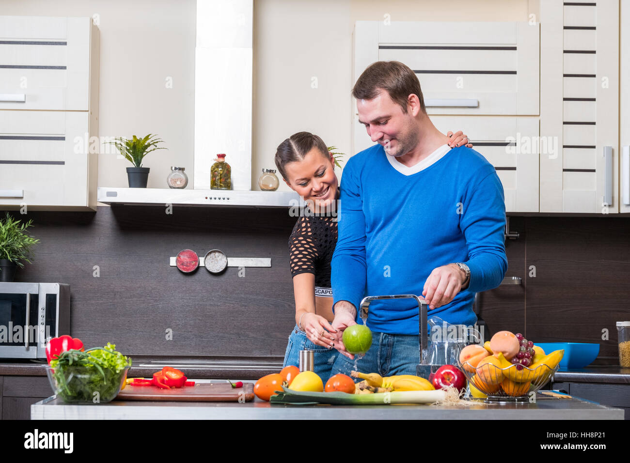 Young couple having fun in the kitchen Stock Photo - Alamy