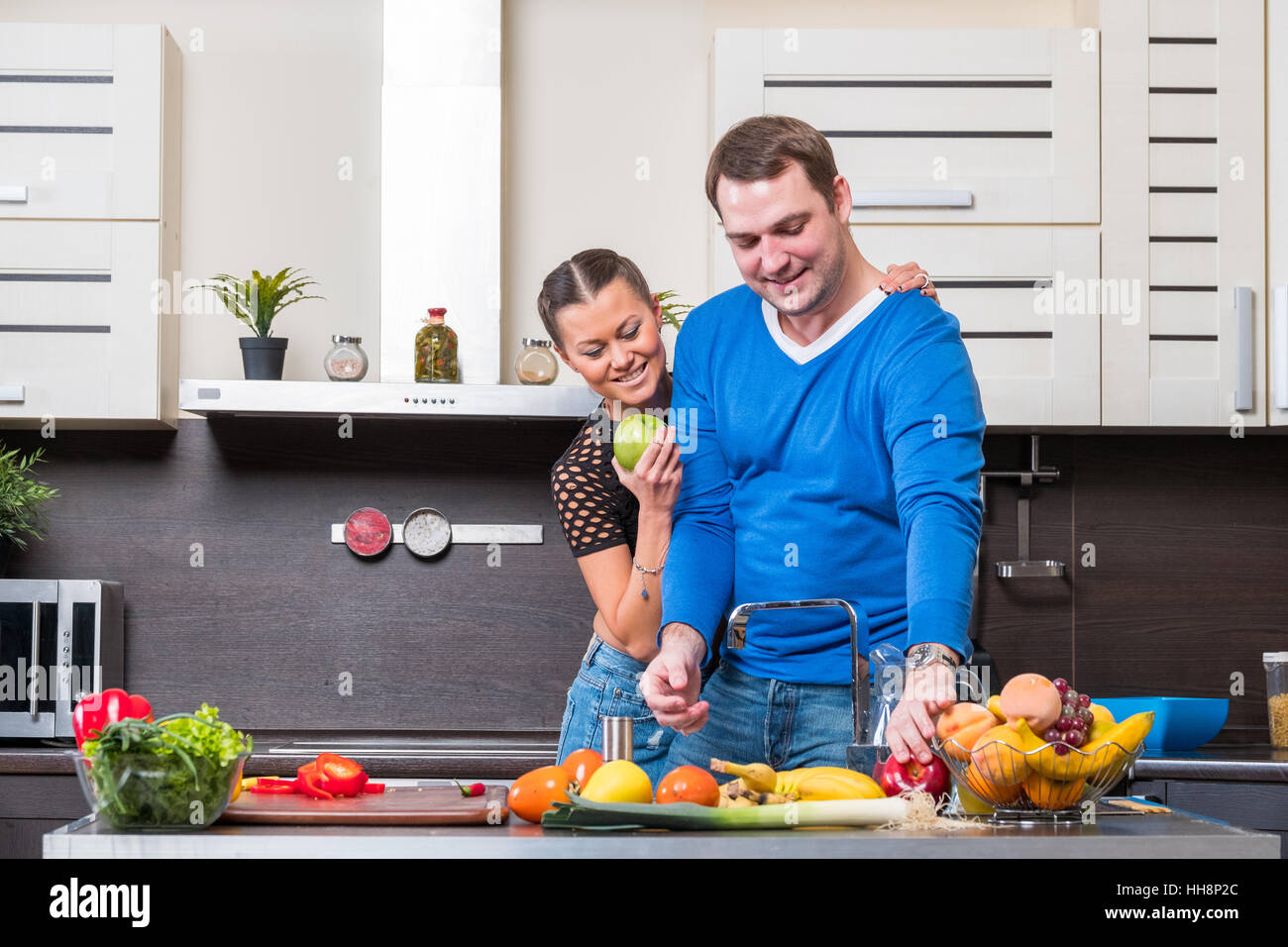 Young couple having fun in the kitchen Stock Photo - Alamy