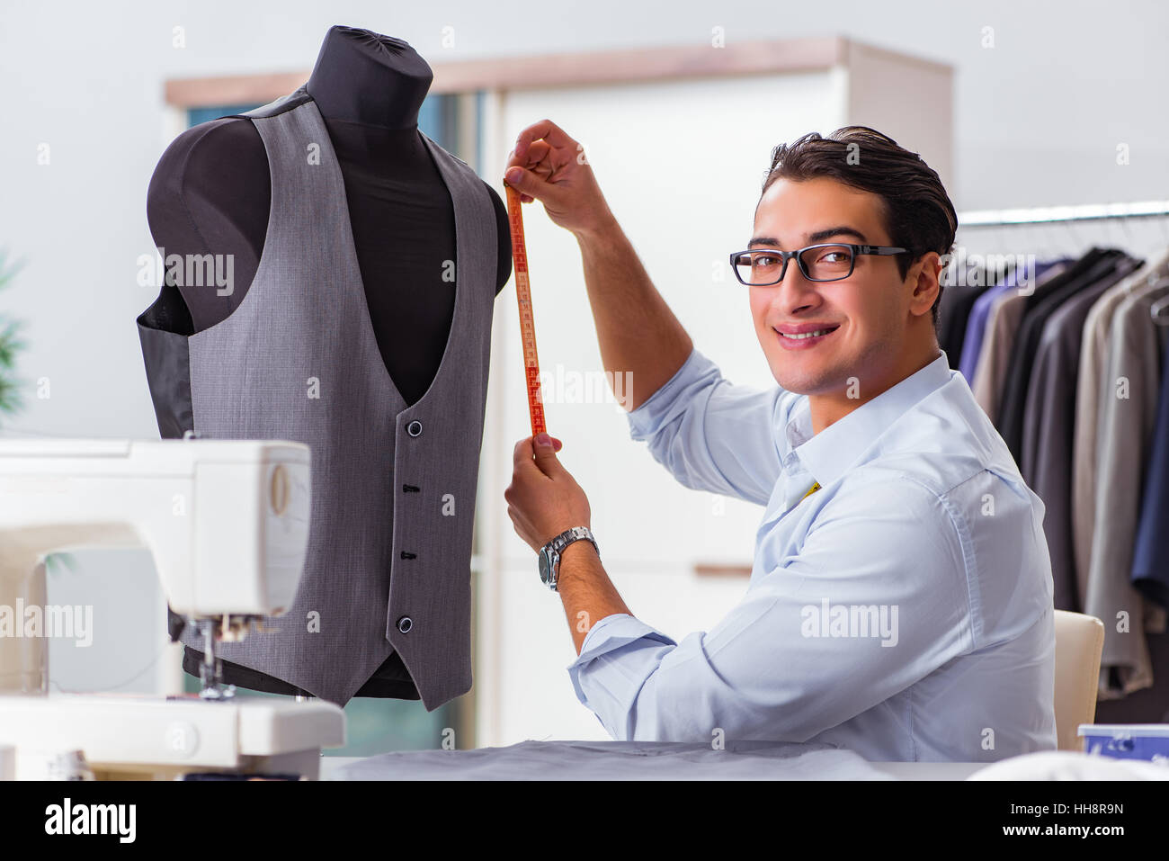 Young man tailor working on new clothing Stock Photo - Alamy