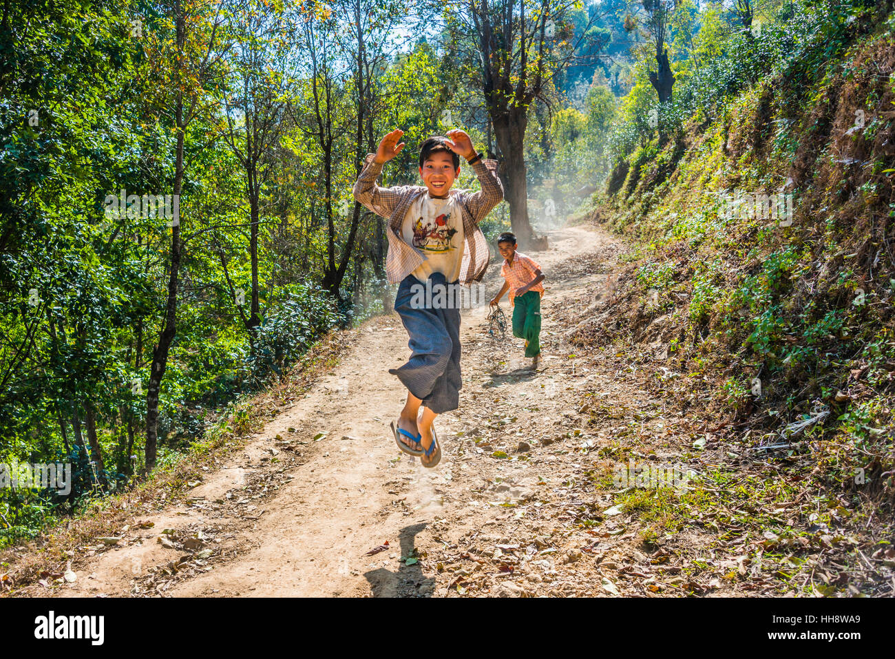 Boy jumping happily on dirt road, Palaung hilltribe, Palaung Village in ...