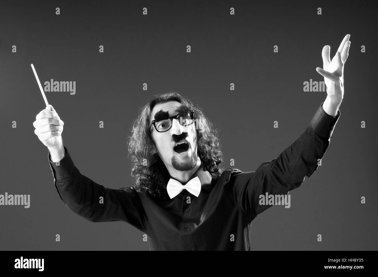 Funny conductor against dark background Stock Photo - Alamy