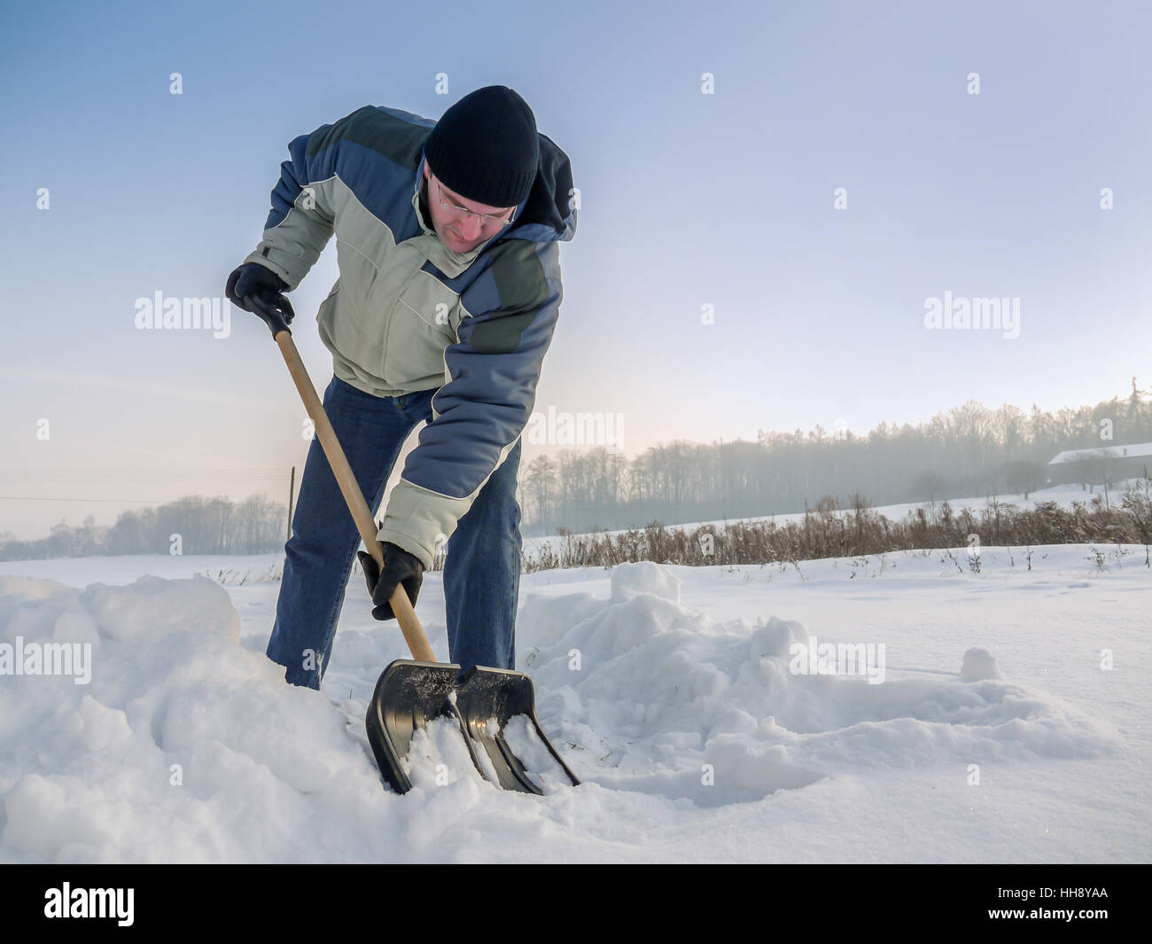 Man plowing his backyard with shovel after heavy snowing Stock Photo ...
